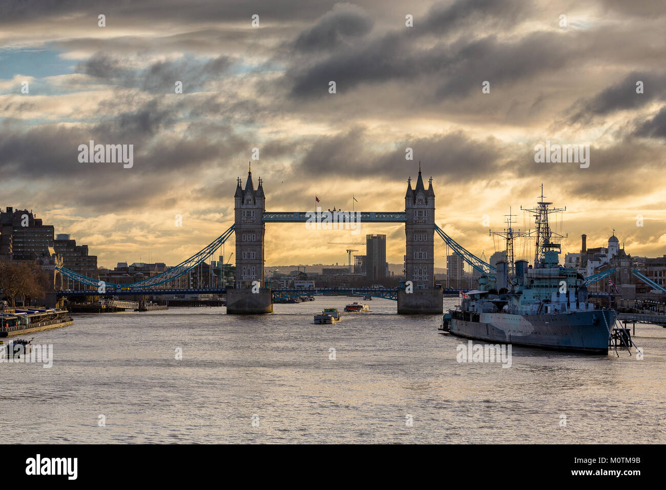 London's Tower Bridge in early morning light with HMS Belfast and cargo ...