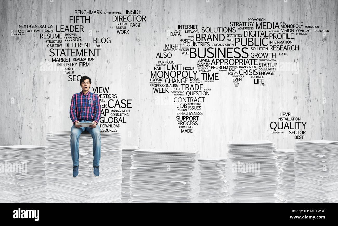 Attractive man sitting on pile of paper documents Stock Photo - Alamy