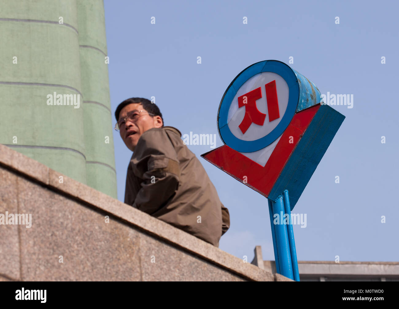 North Korean man in front of a subway sign in the street, Pyongan ...