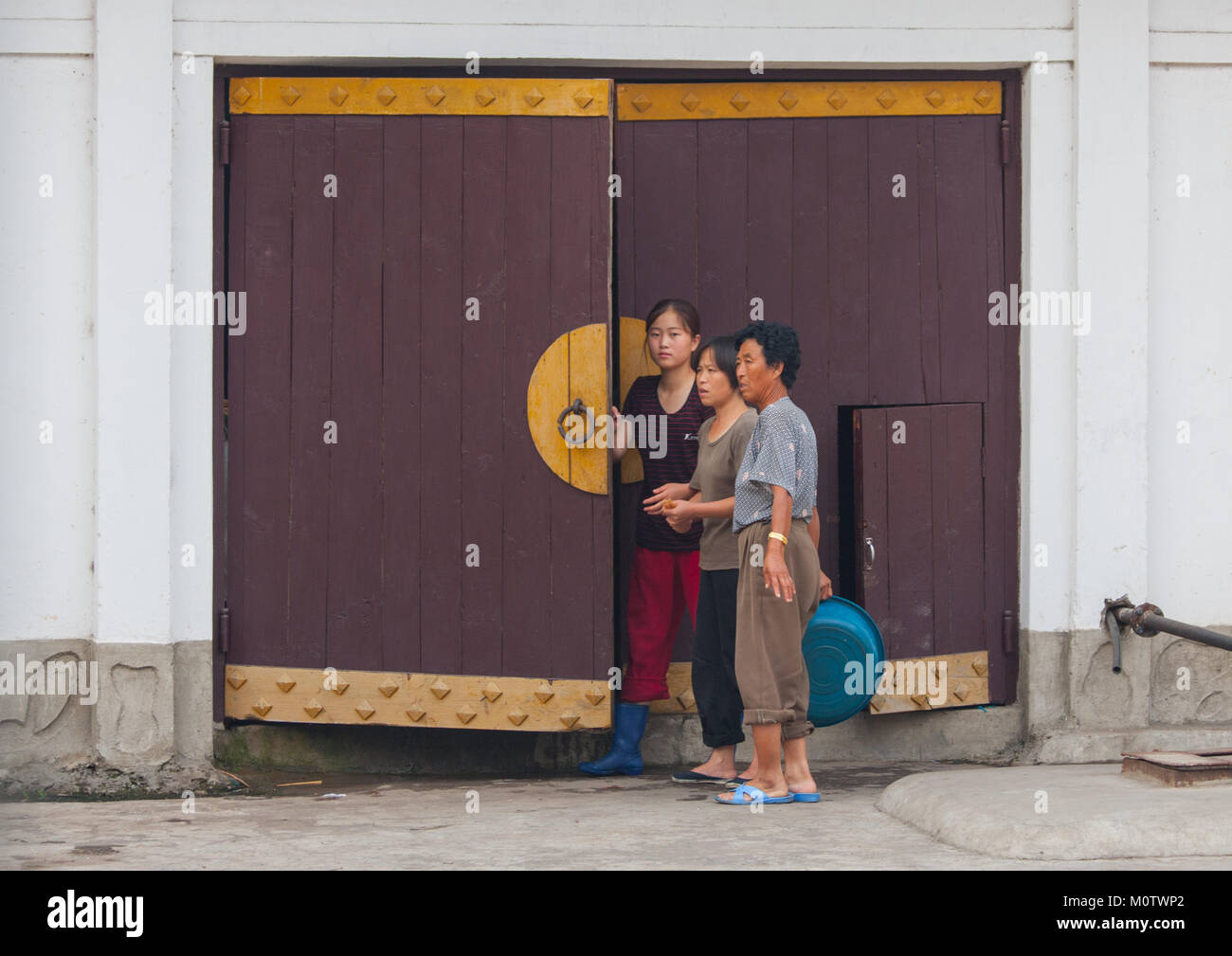 North Korean women in front of a traditional wooden door, North ...