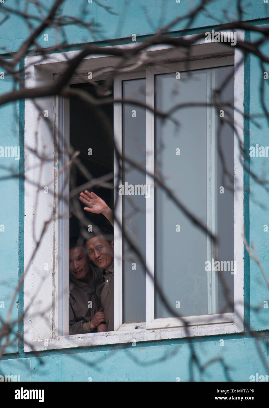 North Korean men waving from a window, Pyongan Province, Pyongyang ...