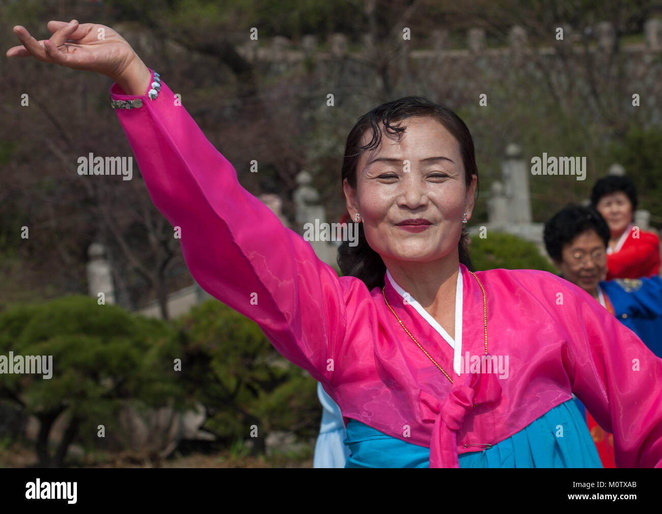 North Korean people dancing in a park for the day of the sun which is ...
