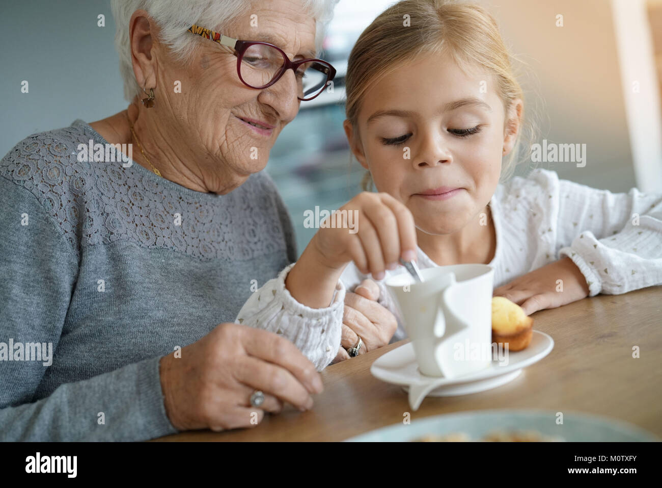 Little girl having tea time with grandma Stock Photo - Alamy