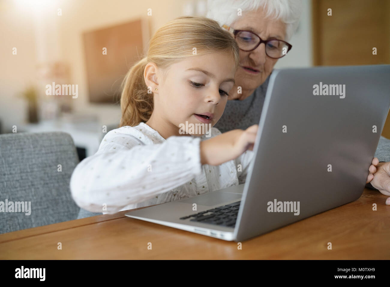 Little girl with grandmother using laptop computer Stock Photo - Alamy