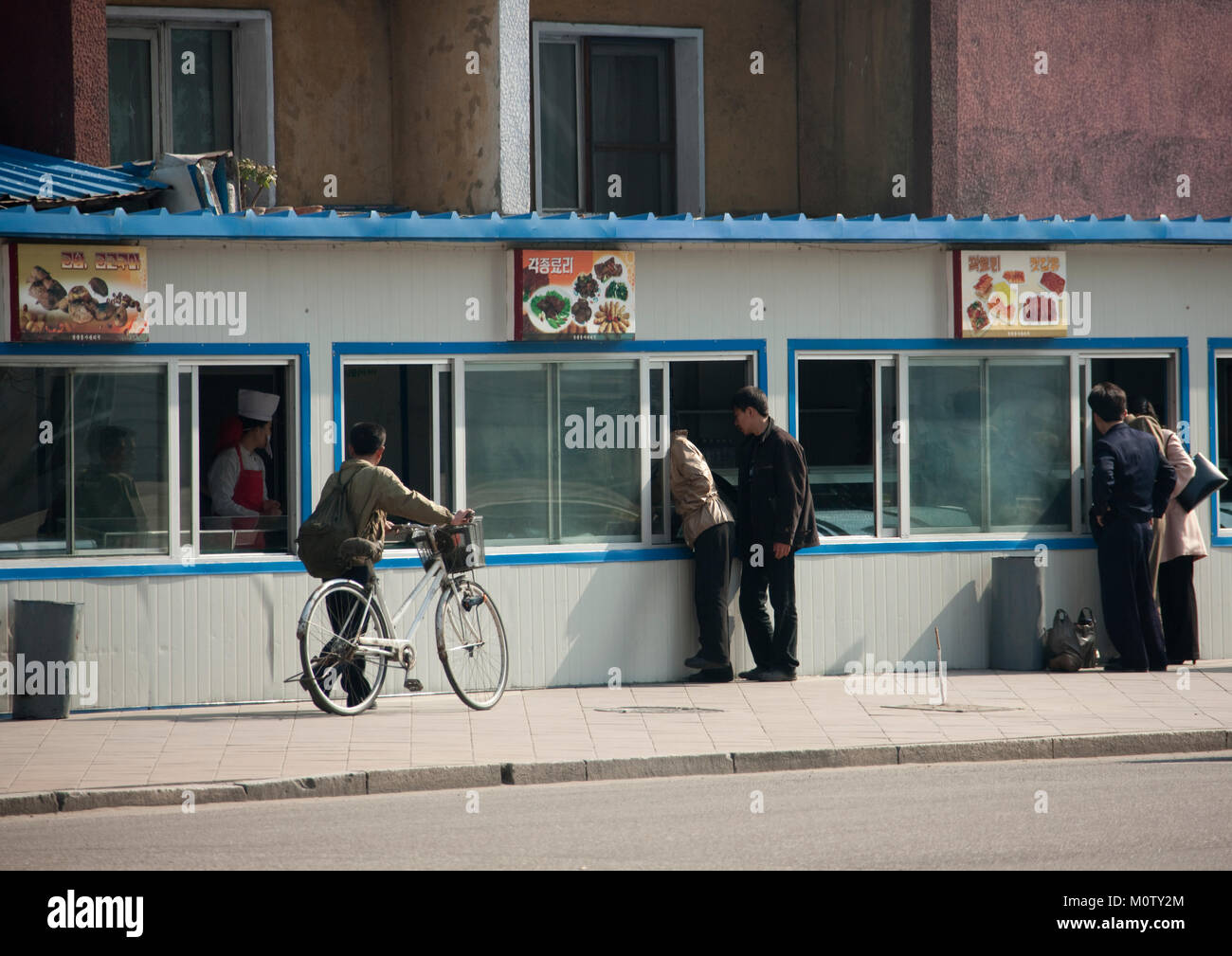 North Korean people byuing food in fast food shops in the city center ...