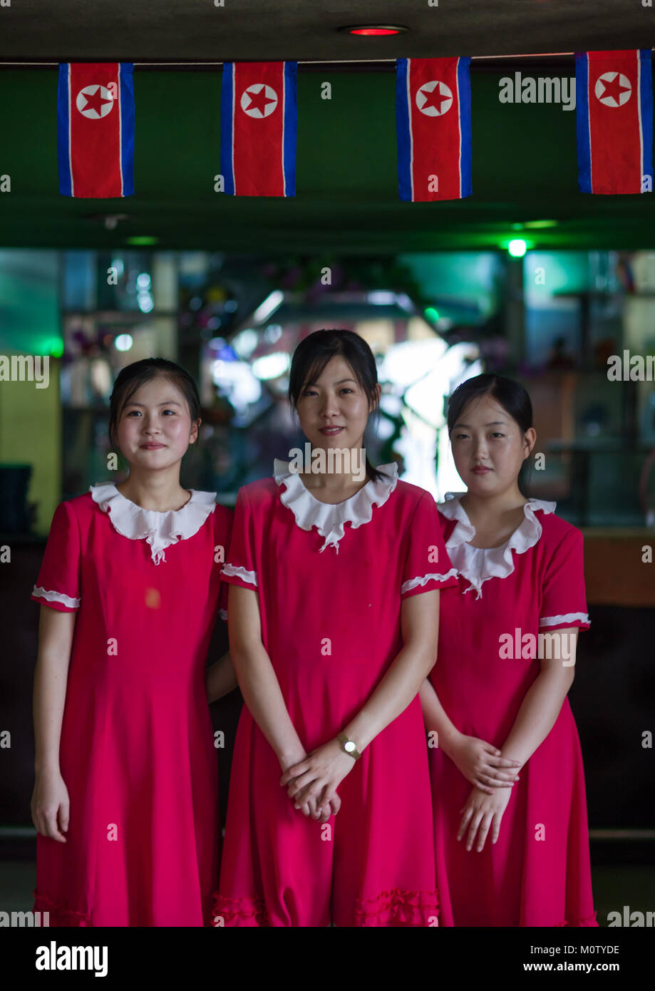 North Korean waitresses in a restaurant decorated with national flags ...