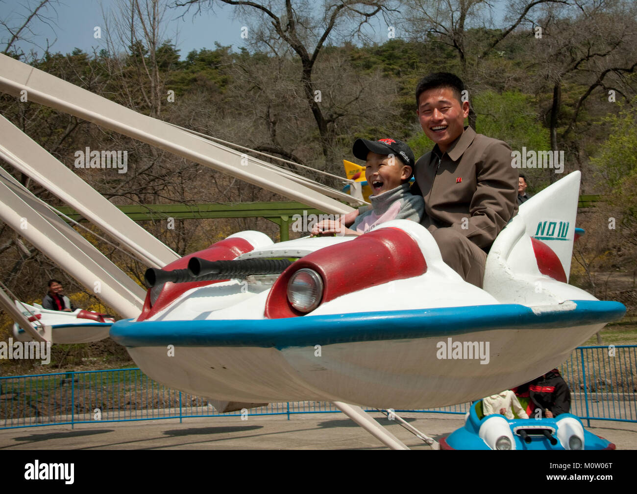 North Korean people having fun on a flying saucer attraction in ...