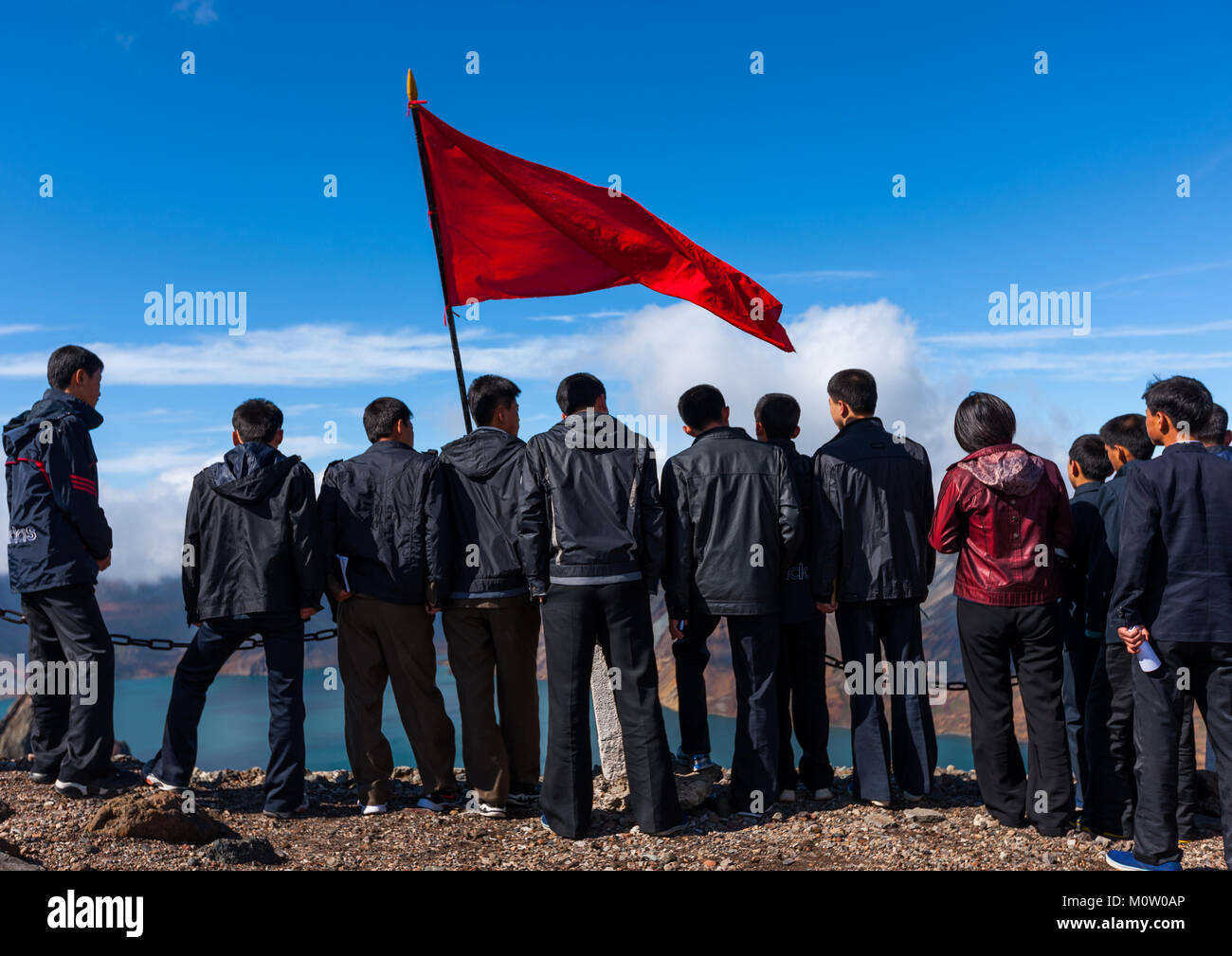 Group of students with red flag in front of lake at mount Paektu ...