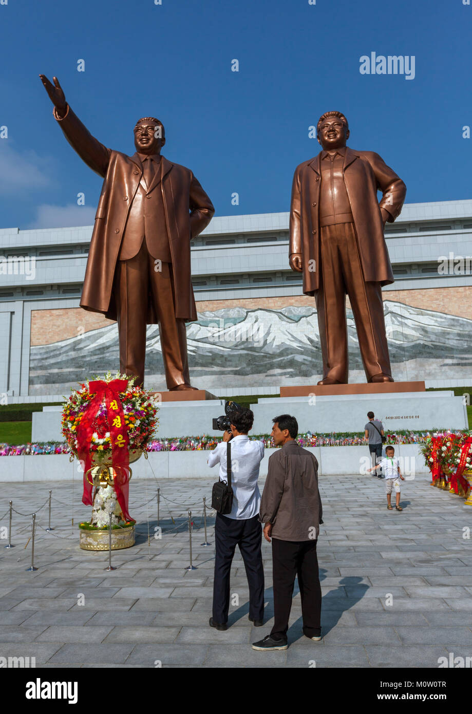 North Korean cameraman in front of the statues of the Dear Leaders in ...