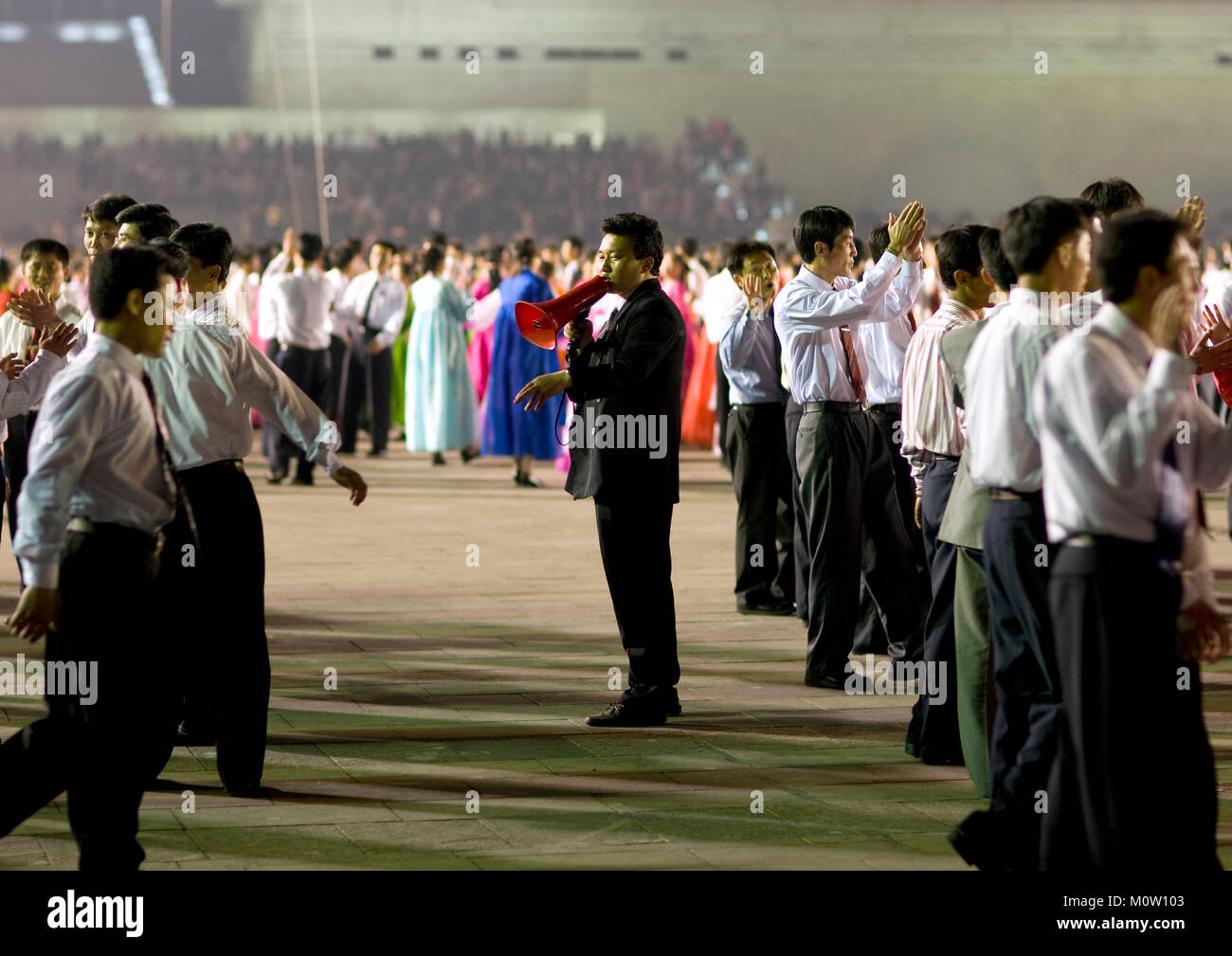 North Korean man with a megaphone giving orders to students dancing to ...