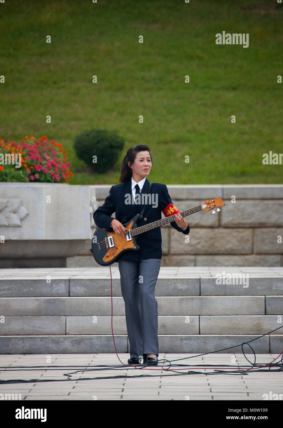 North Korean young woman playing bass in a park, Pyongan Province ...