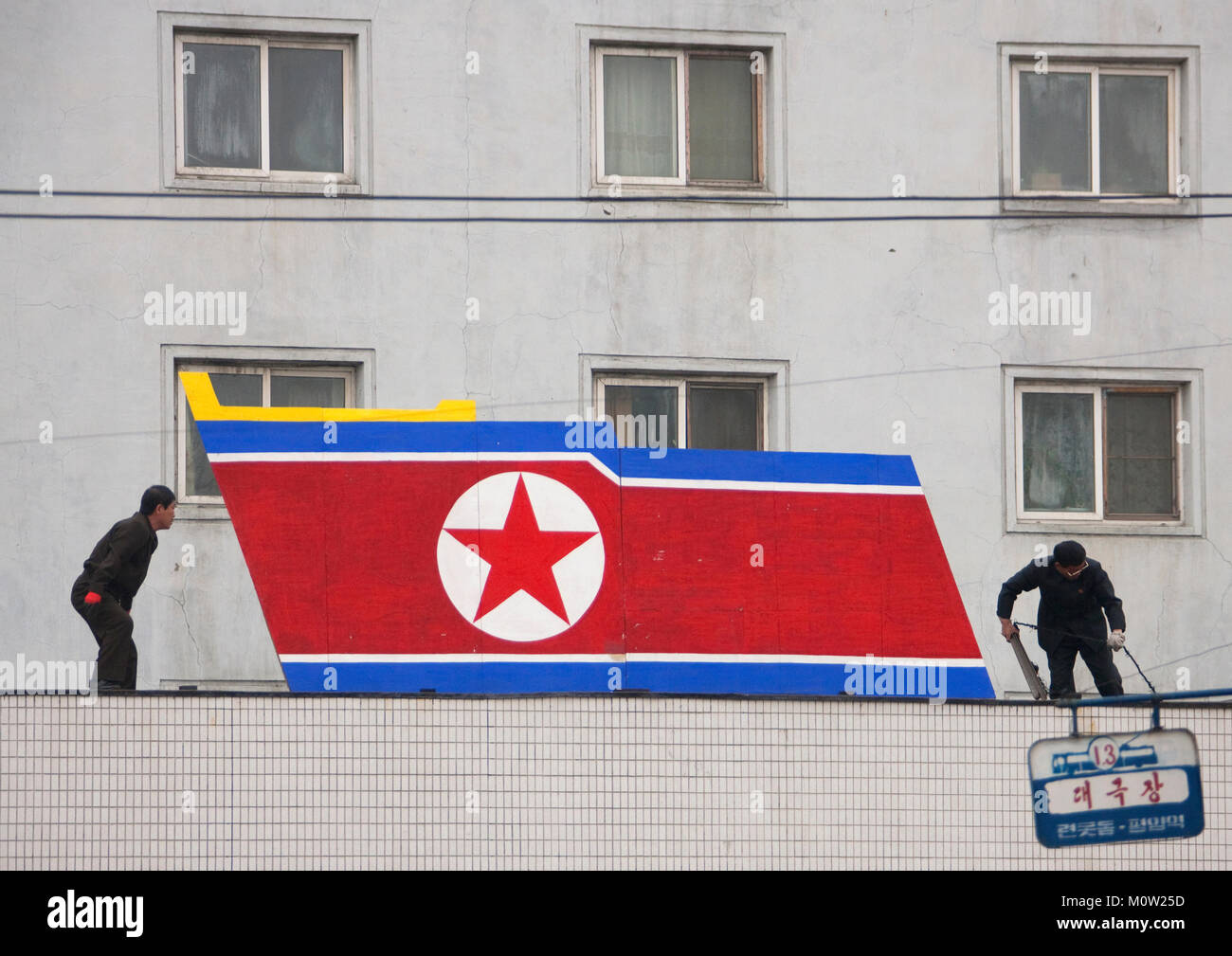 North Korean men setting a giant flag on a building, Pyongan Province ...