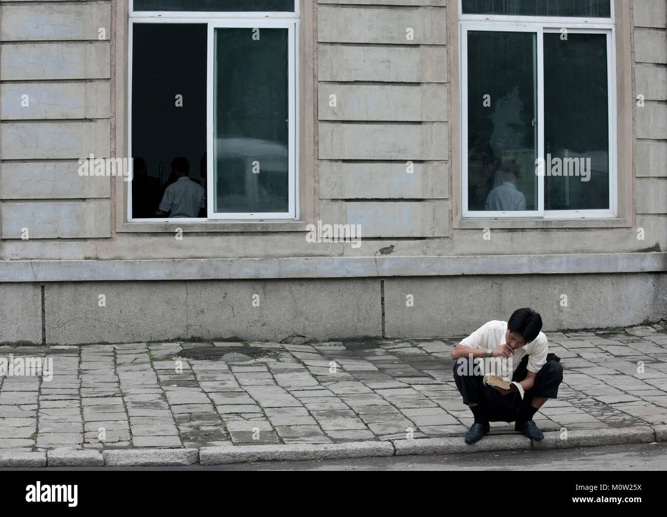North Korean man reading a book in the street, Pyongan Province ...