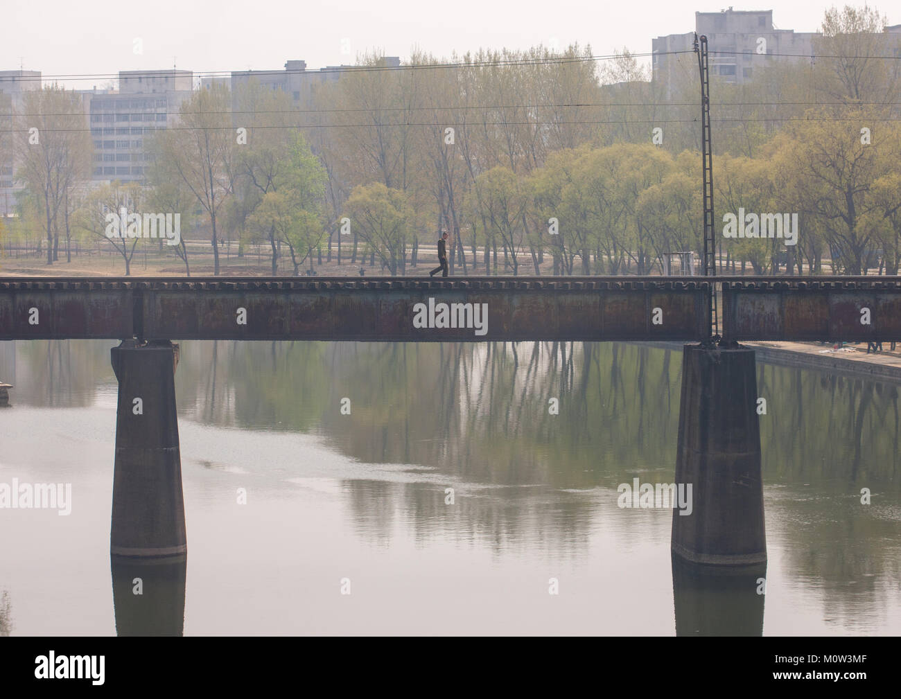 North Korean man crossing an empty railway bridge, Pyongan Province ...