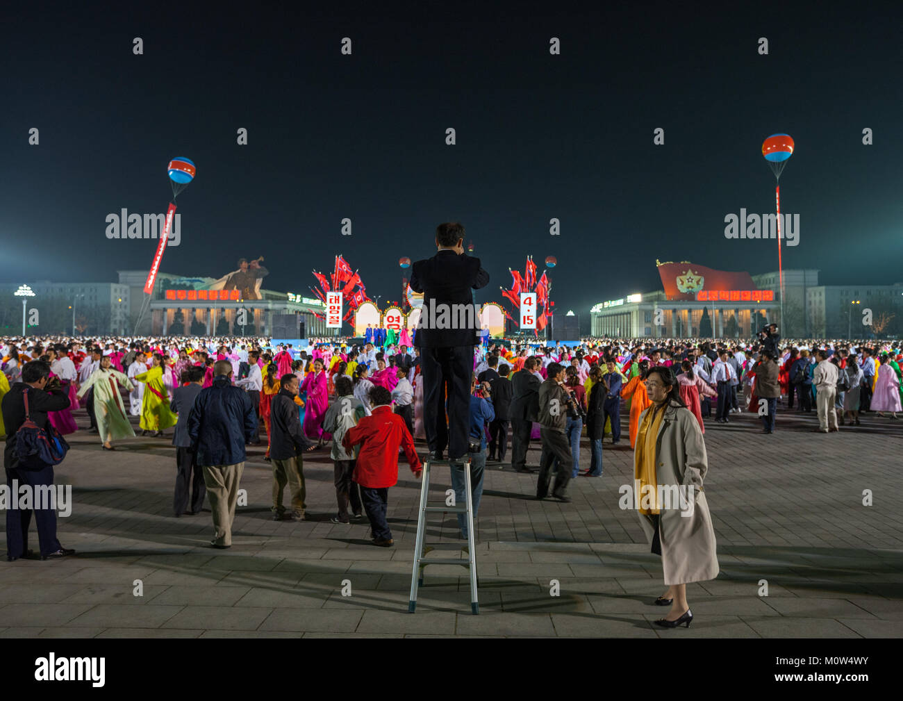 Man on a ladder taking pictures of North Korean students dancing to ...