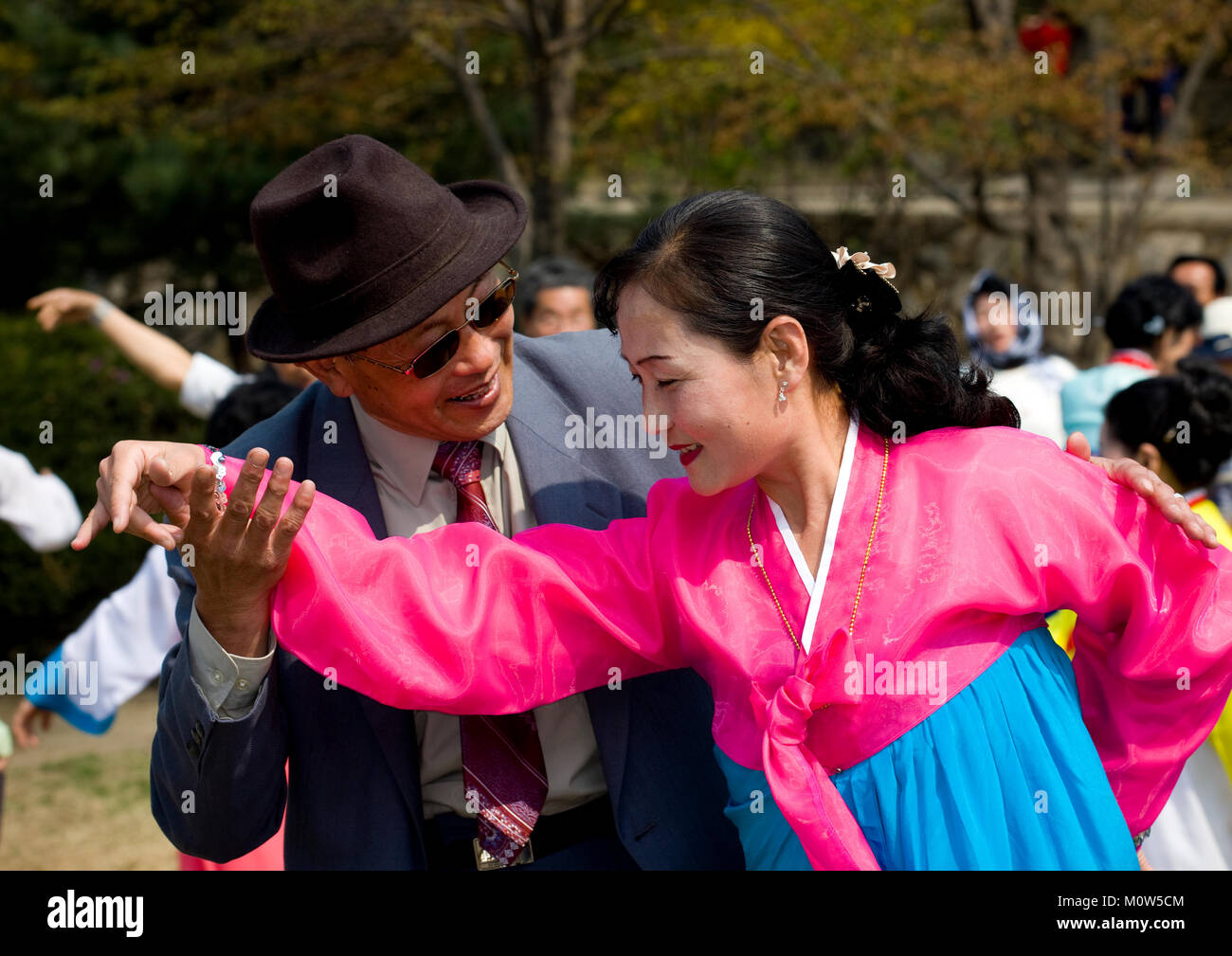 North Korean people dancing in a park for the day of the sun which is ...