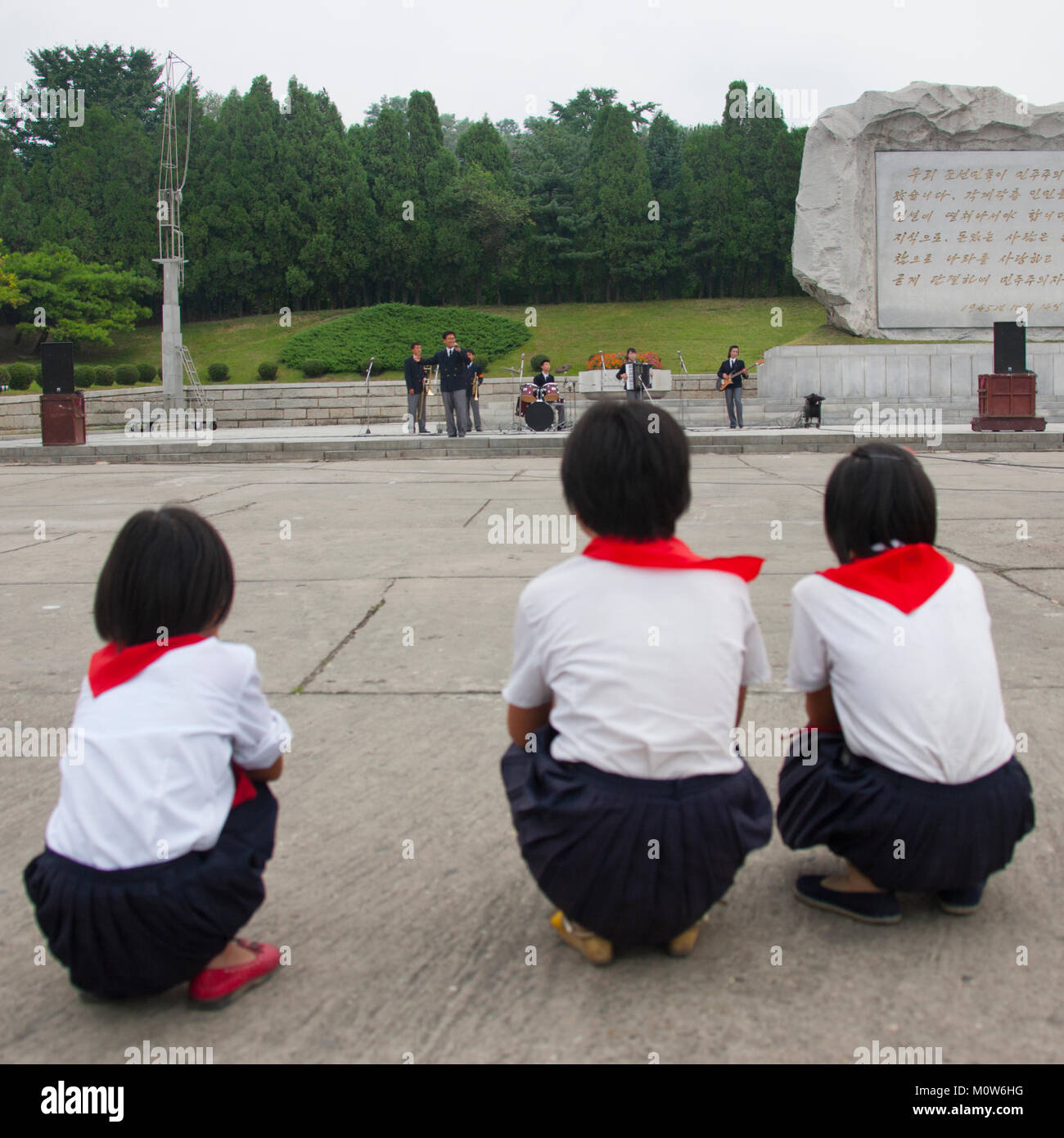 North Korean pioneers listening to a band playing music on national day ...