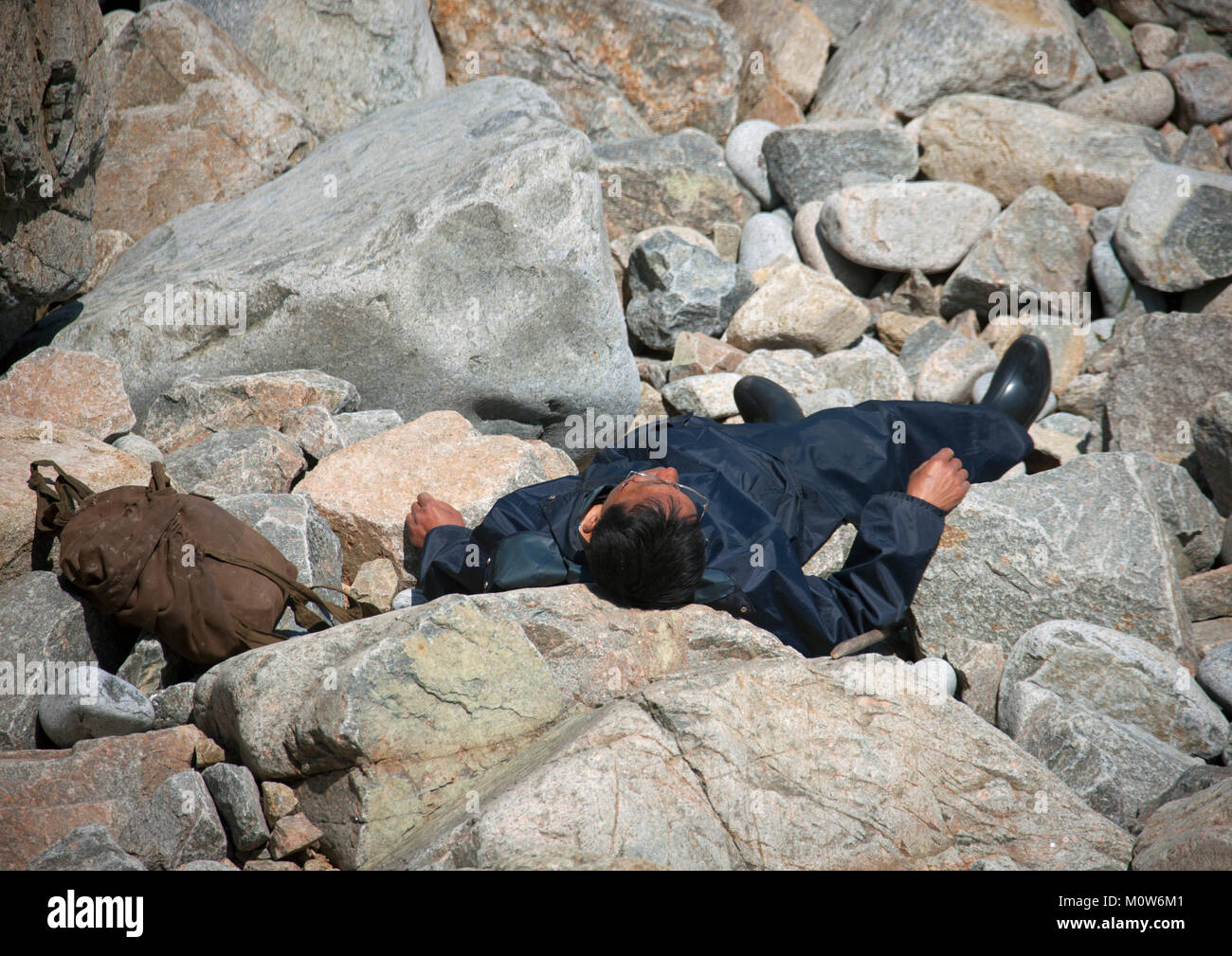North Korean man sleeping on rocks under the sun, North Hamgyong ...