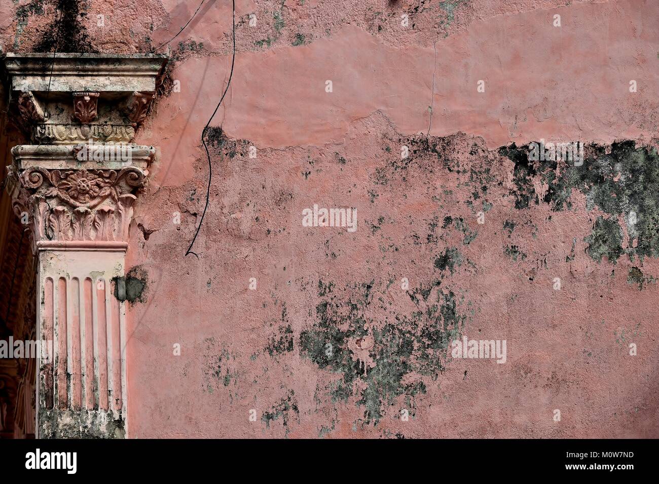 Close up of neoclassical stone column against the weathered pink wall ...