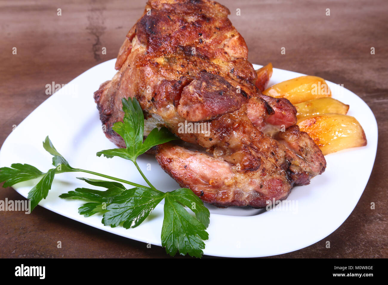 Juicy pork neck chops are grilled with potatoes on a white plate Stock ...