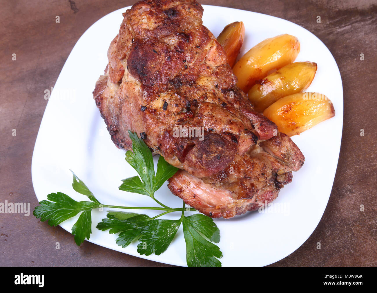 Juicy pork neck chops are grilled with potatoes on a white plate Stock ...