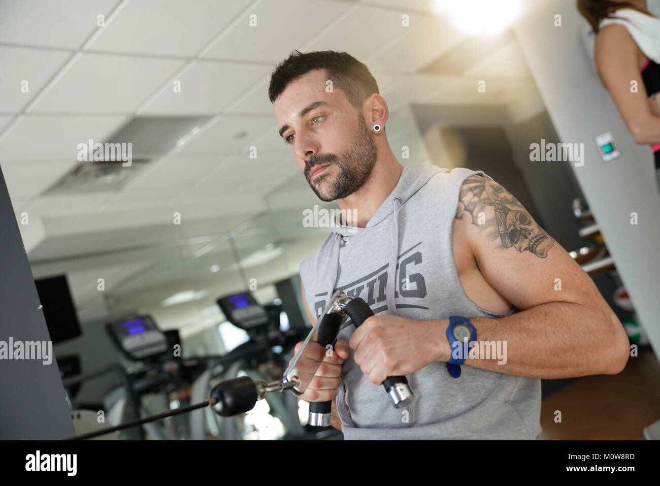 Athletic guy in fitness room lifting weight Stock Photo - Alamy