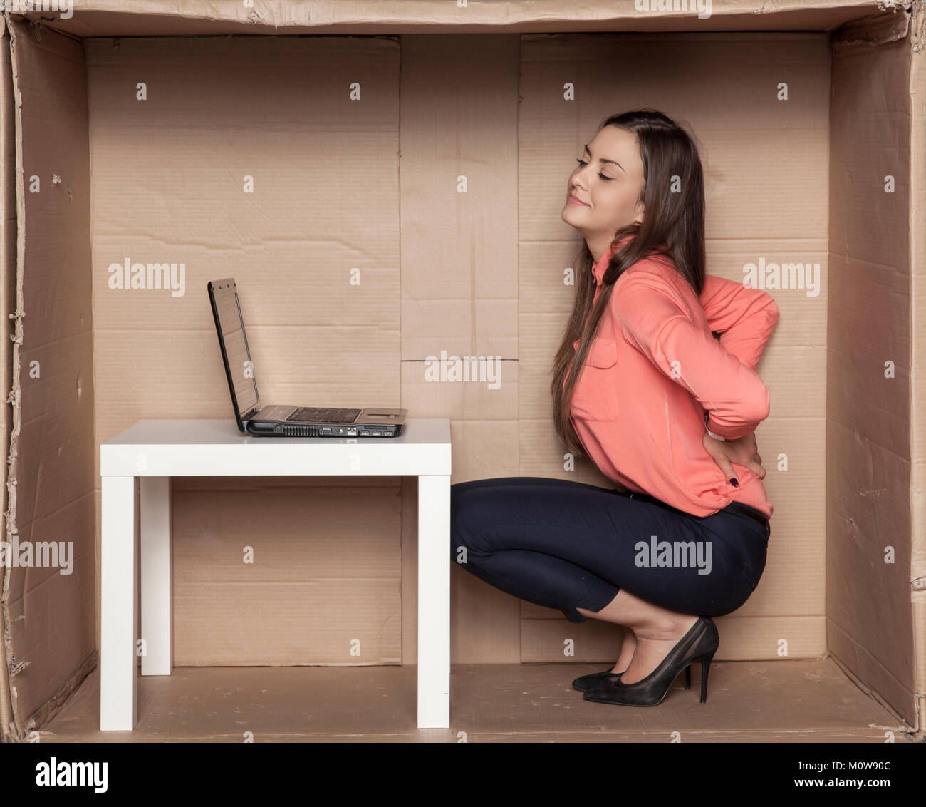back pain from a bad position in the office Stock Photo - Alamy