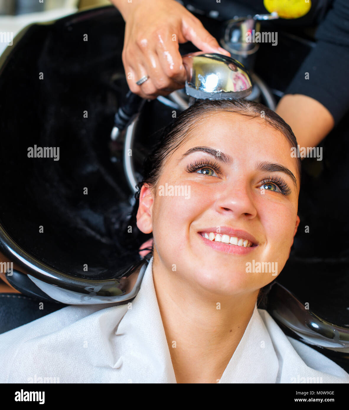 Beautiful young woman with hairdresser washing head at hair salon Stock ...