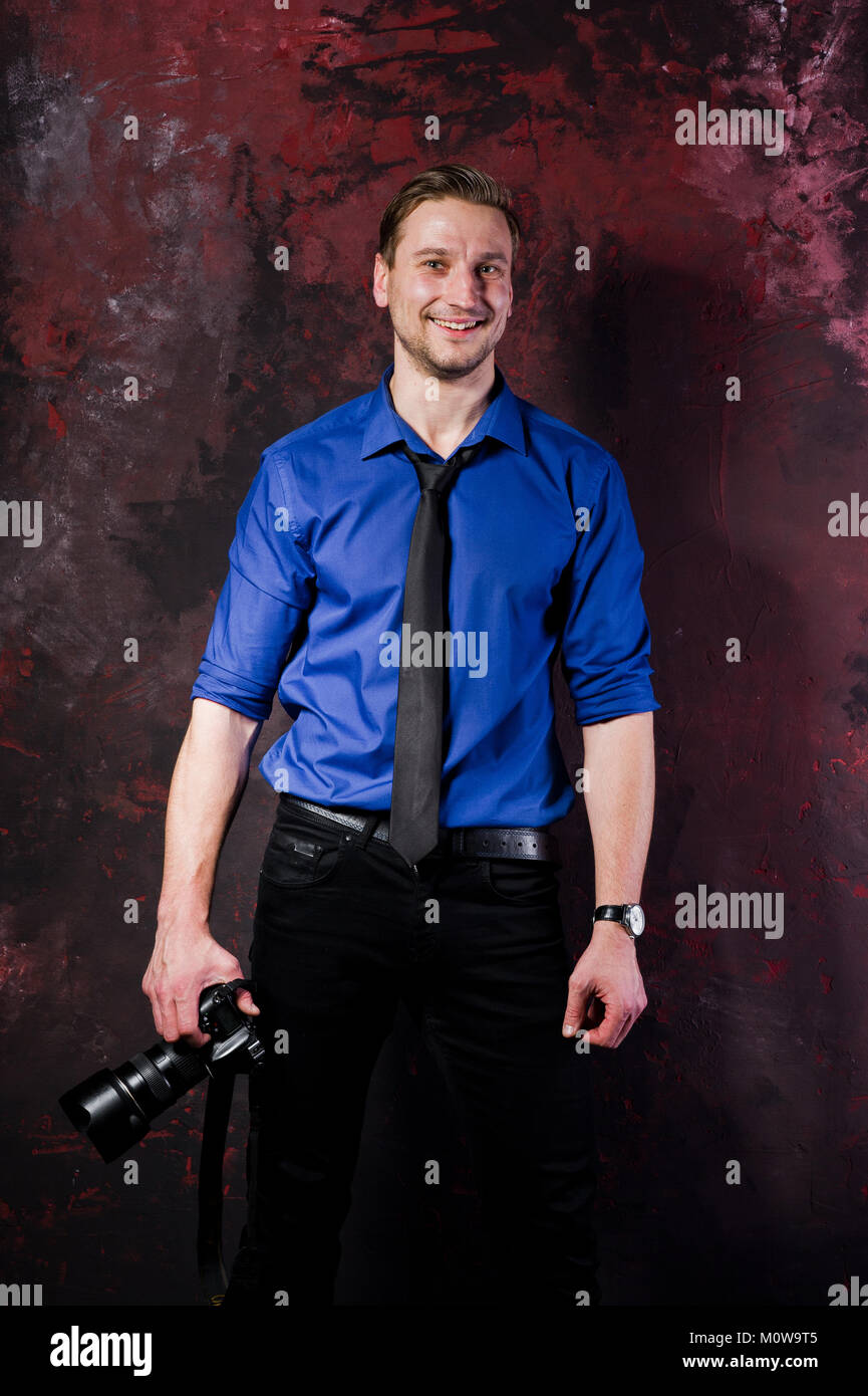 Studio portrait of stylish professional photographer man with camera ...