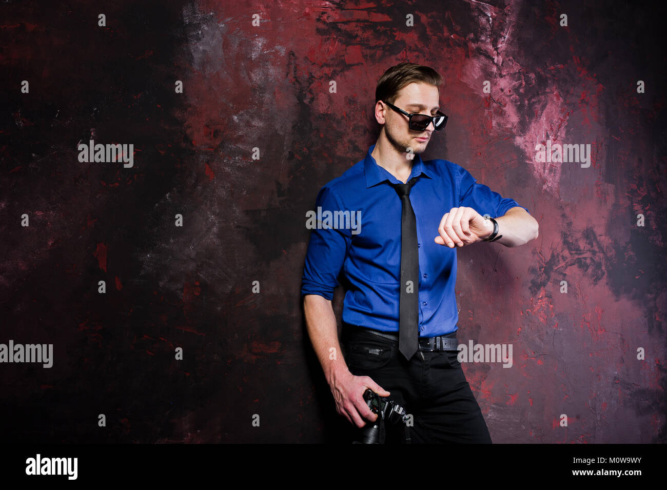 Studio portrait of stylish professional photographer man with camera ...