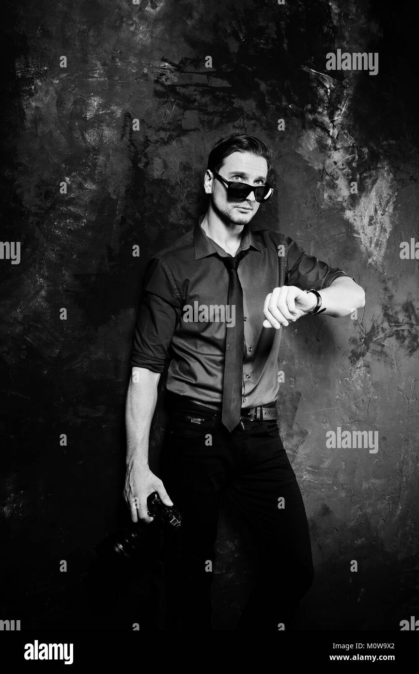 Studio portrait of stylish professional photographer man with camera ...