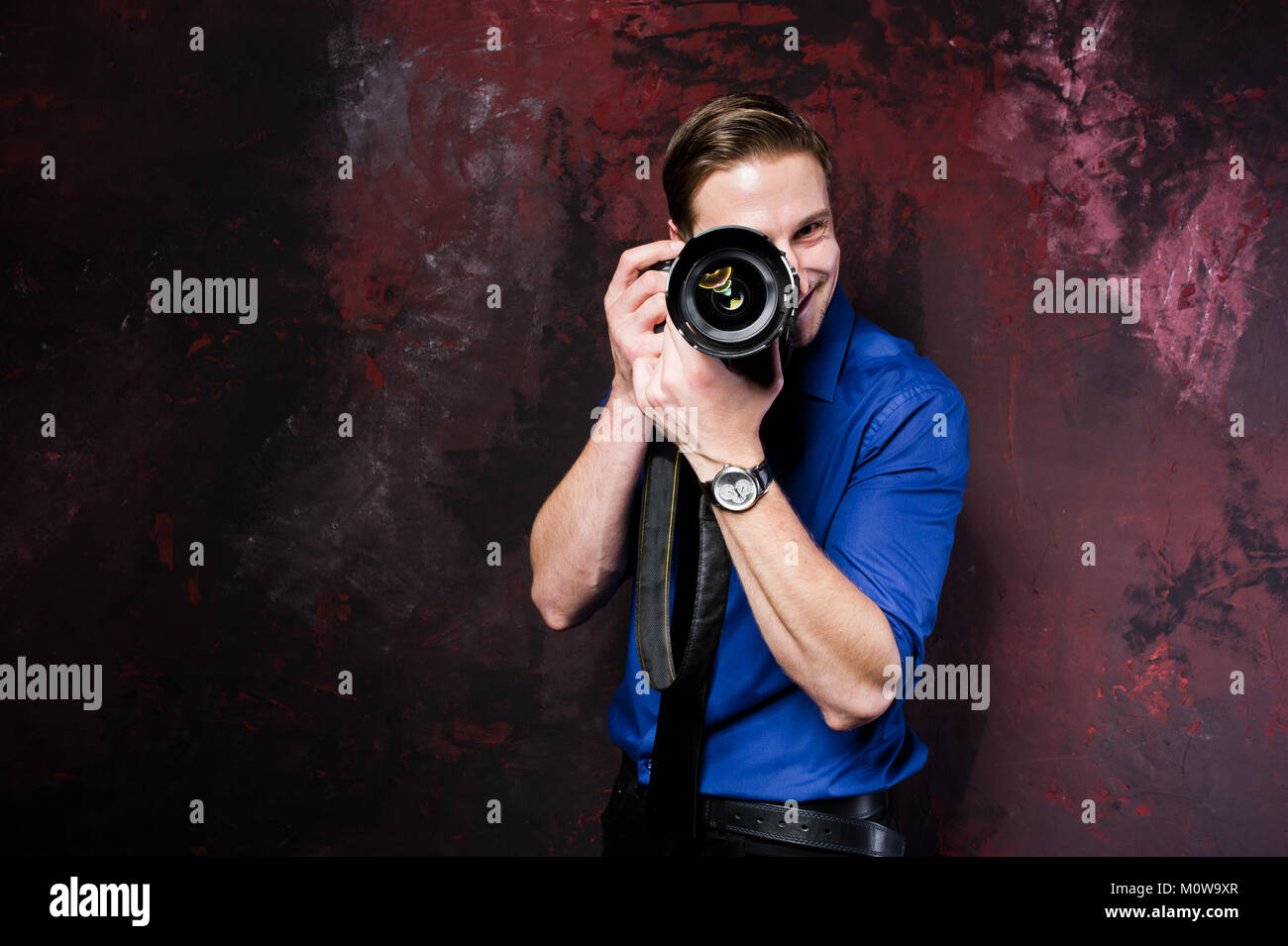 Studio portrait of stylish professional photographer man with camera ...