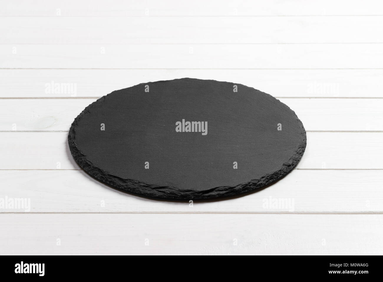 Slate plate on table. black slate stone on wooden background. copy ...