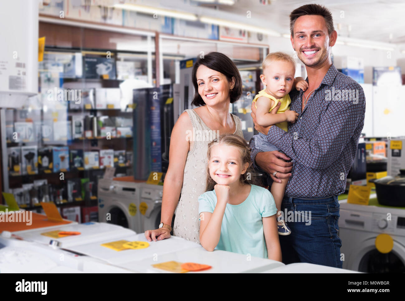 Cheerful family of four shopping goods in household hypermarket Stock ...