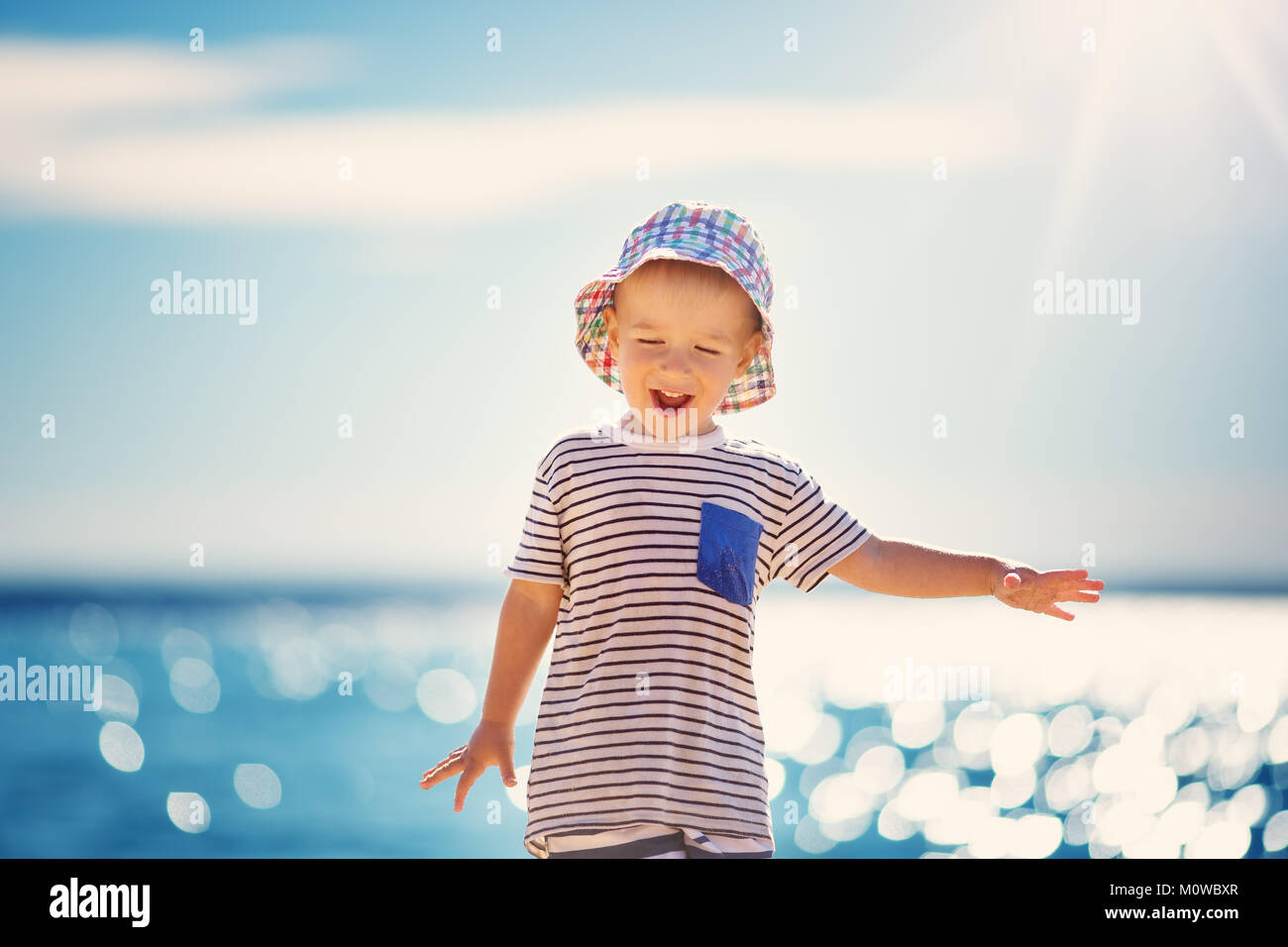 happy boy smiling at the beach in hat Stock Photo - Alamy