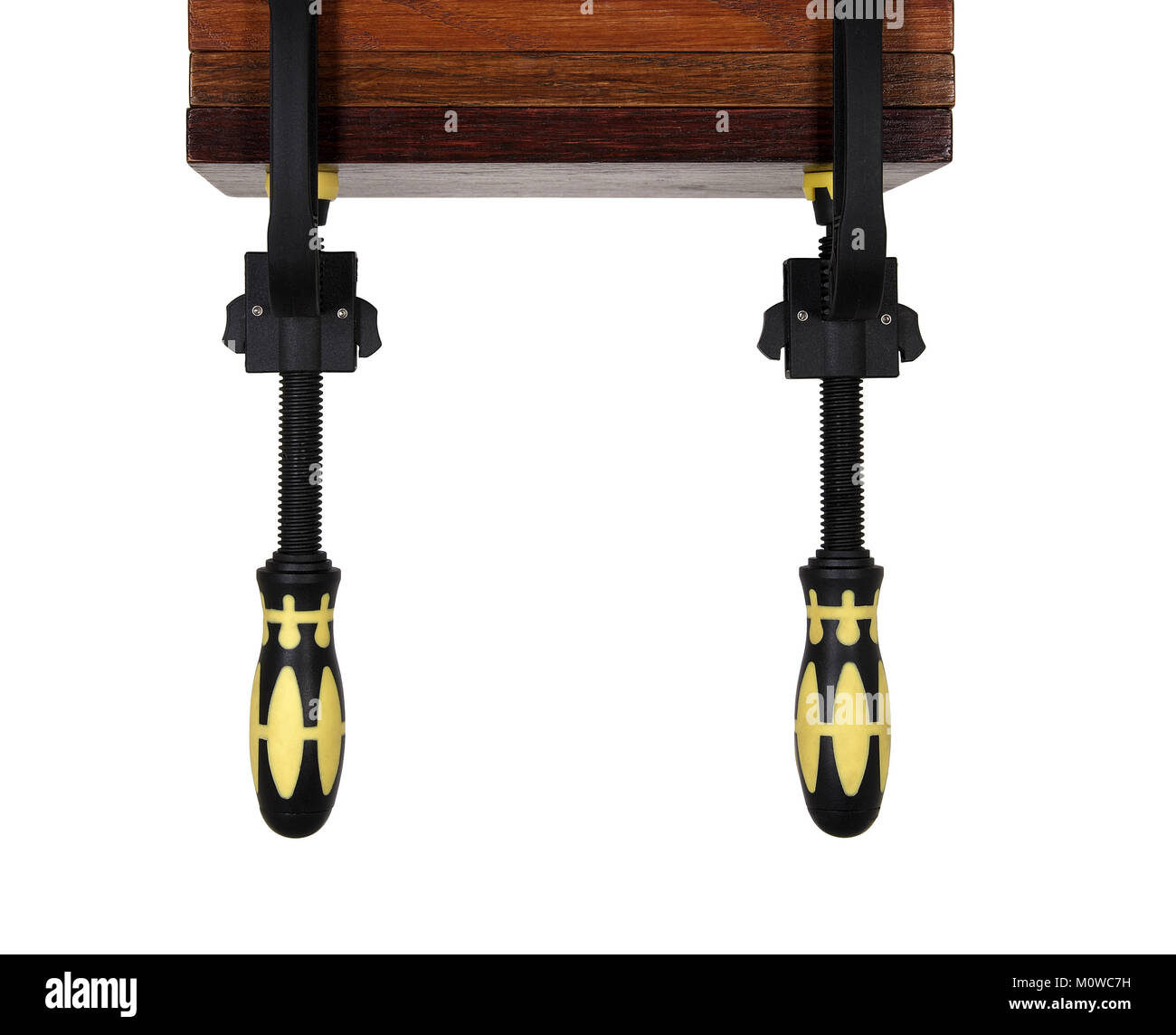 clamps of yellow color hold wooden bars on a white background. Use F ...
