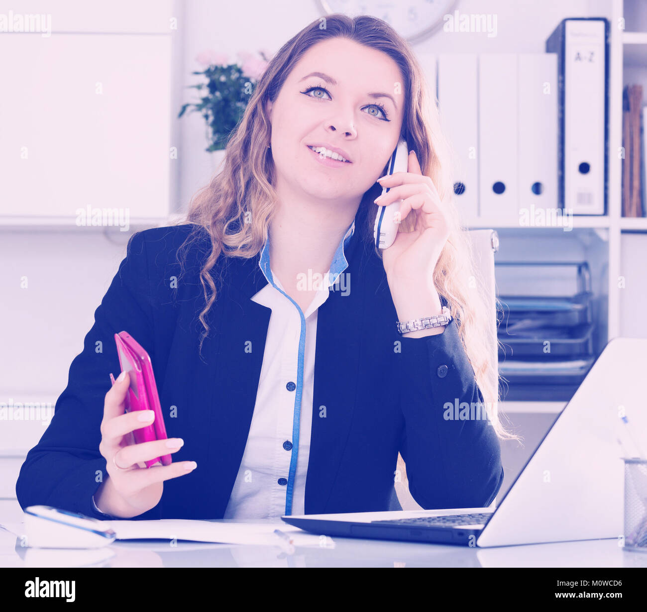 Young and smiling woman office worker talking on the phone Stock Photo ...