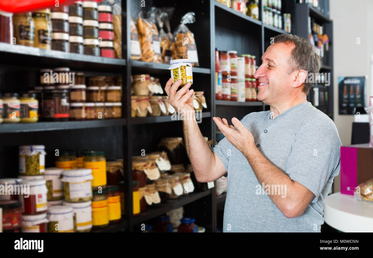 Portrait of senior client choosing food products in deli grocery Stock ...
