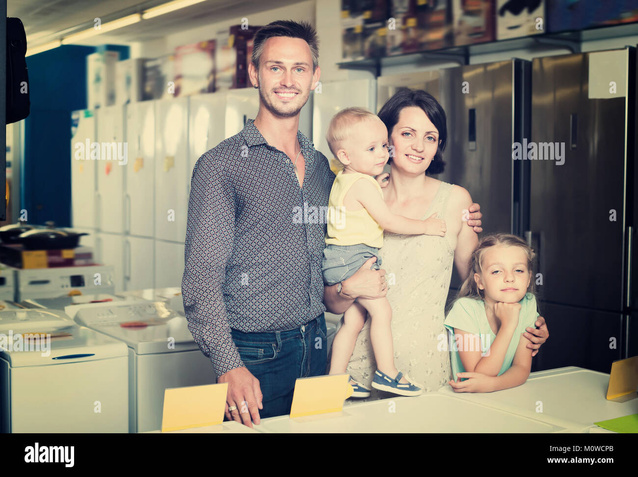 Positive family with two children shopping together in shop of ...
