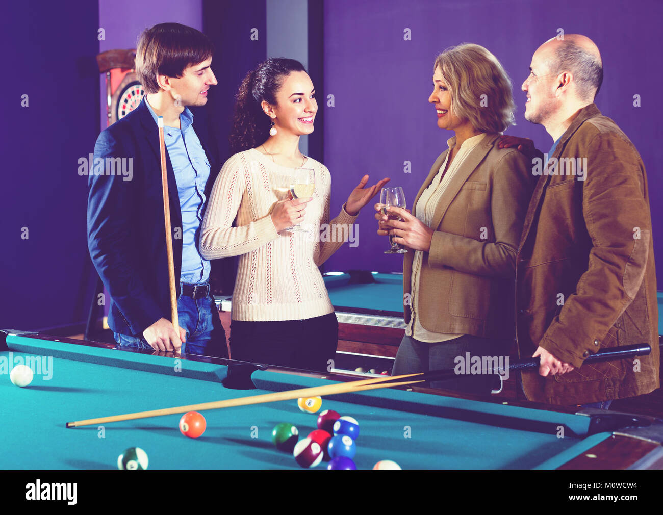 Group of different age friends drinking wine at billiard table Stock ...