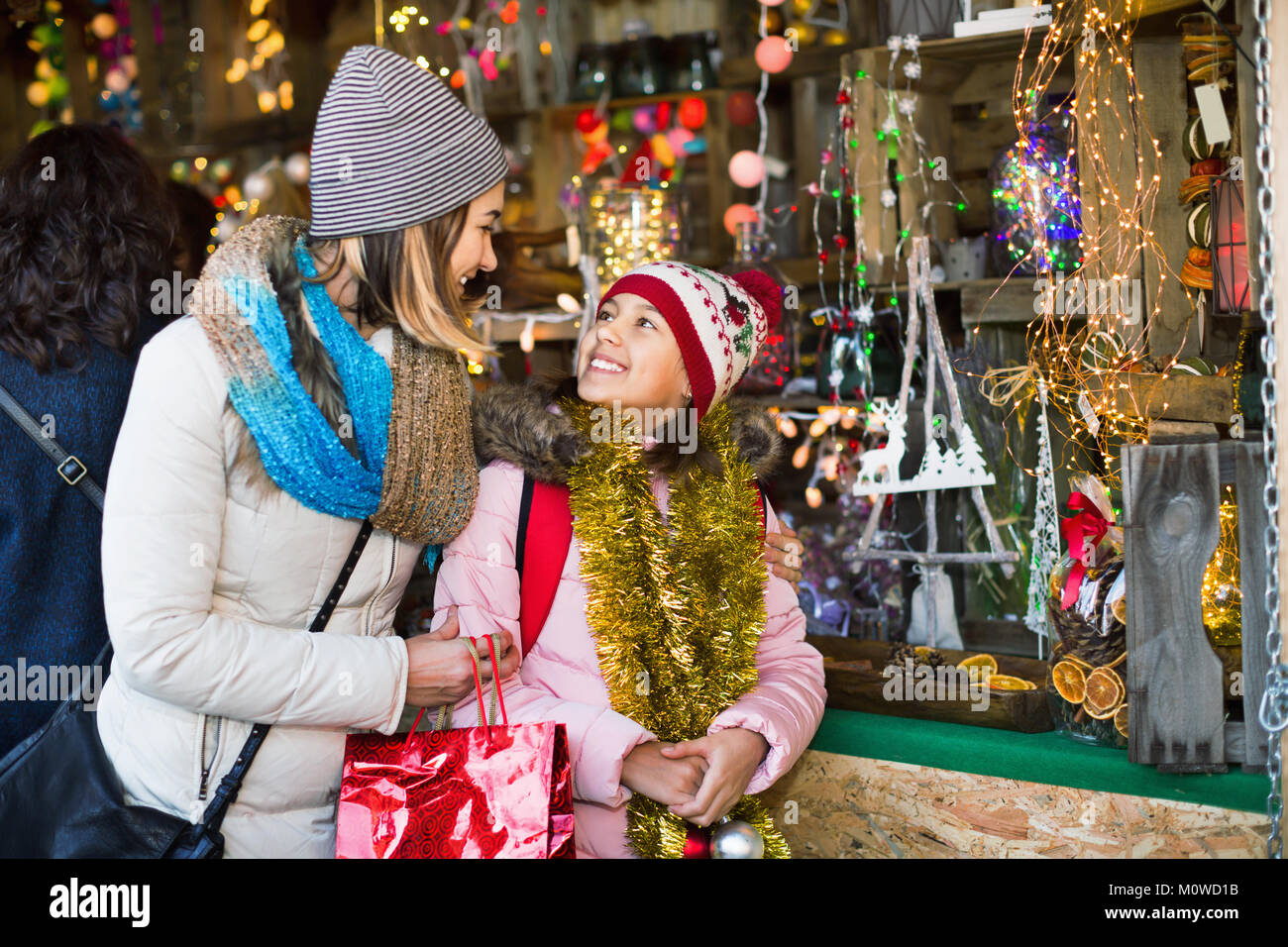 Cheerful female customers staring at counter of Christmas market. Focus ...