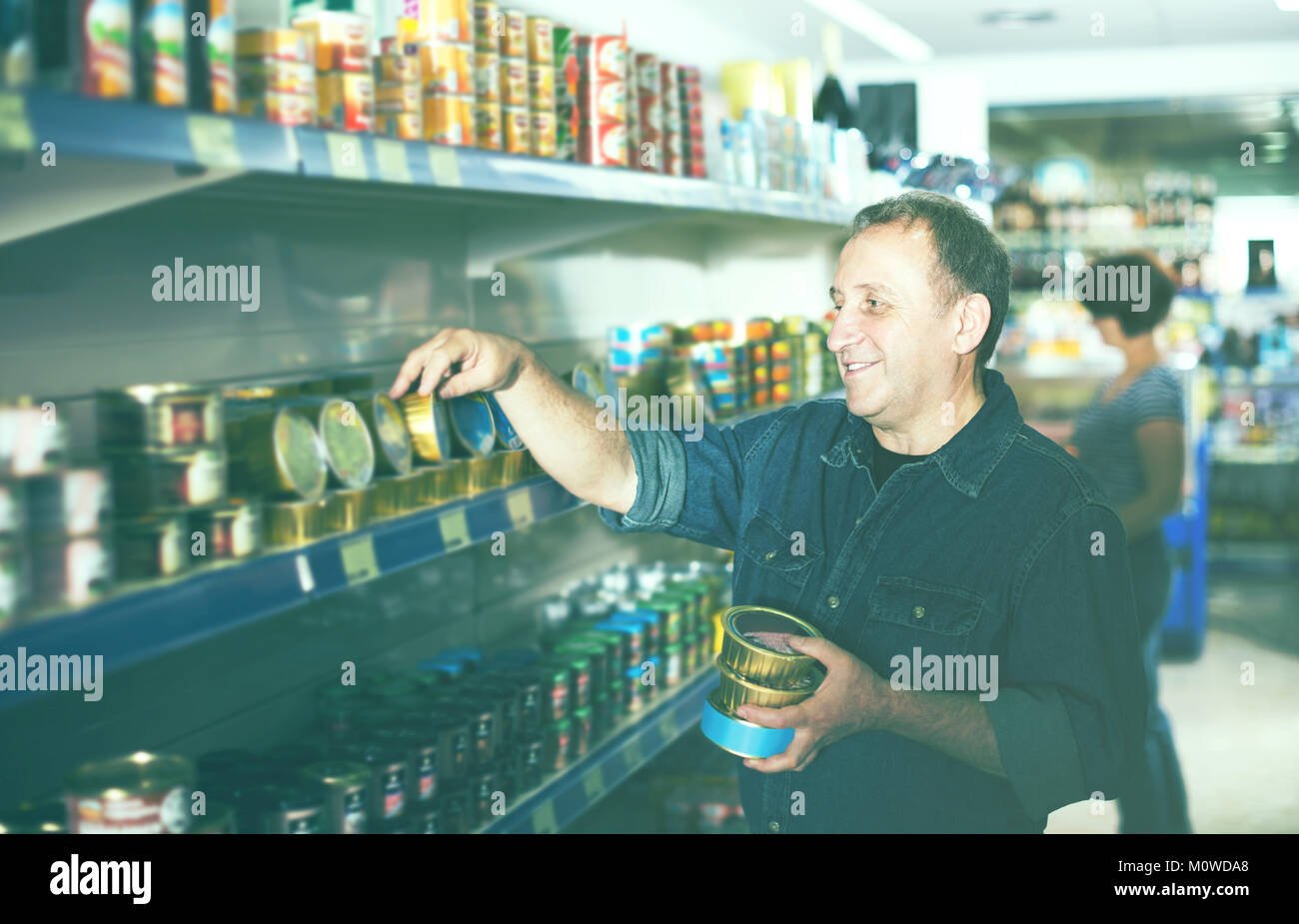 Cheerful pensioner selecting a preserves at the grocery store Stock ...