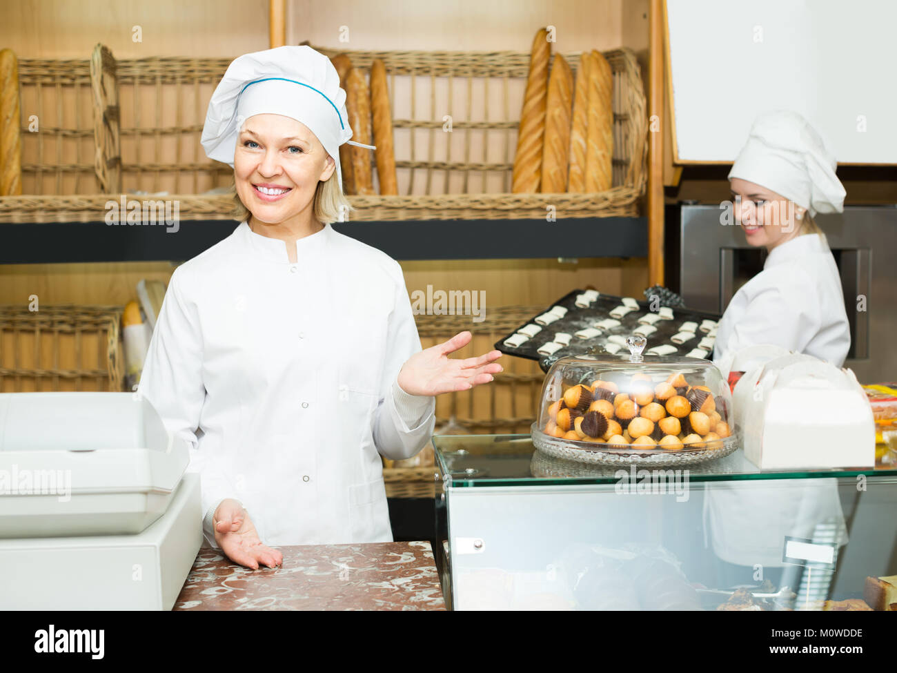 Portrait of friendly female bakers with pastry smiling in bakery Stock ...