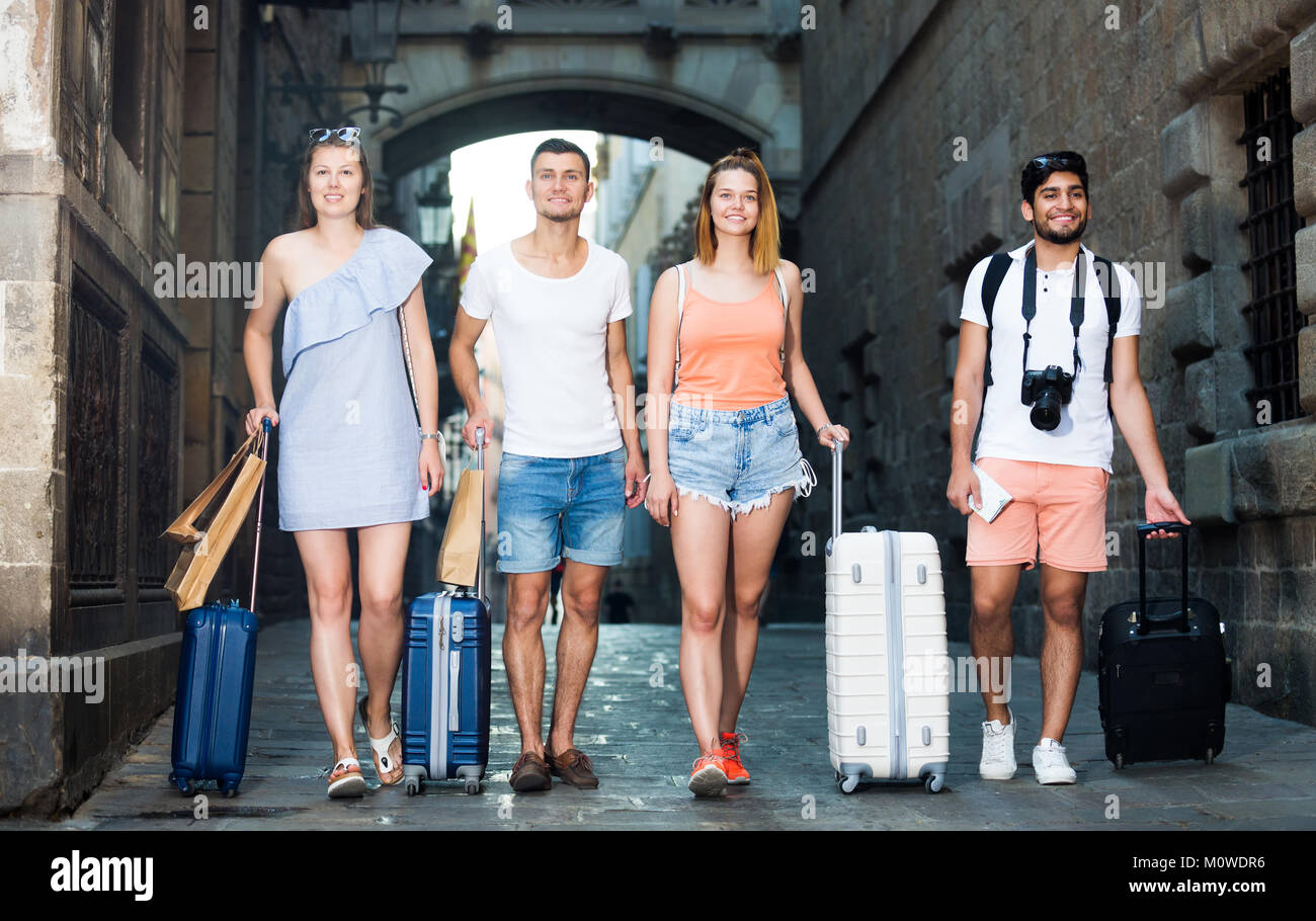 Group of young people tourists walking in city together in summer day ...