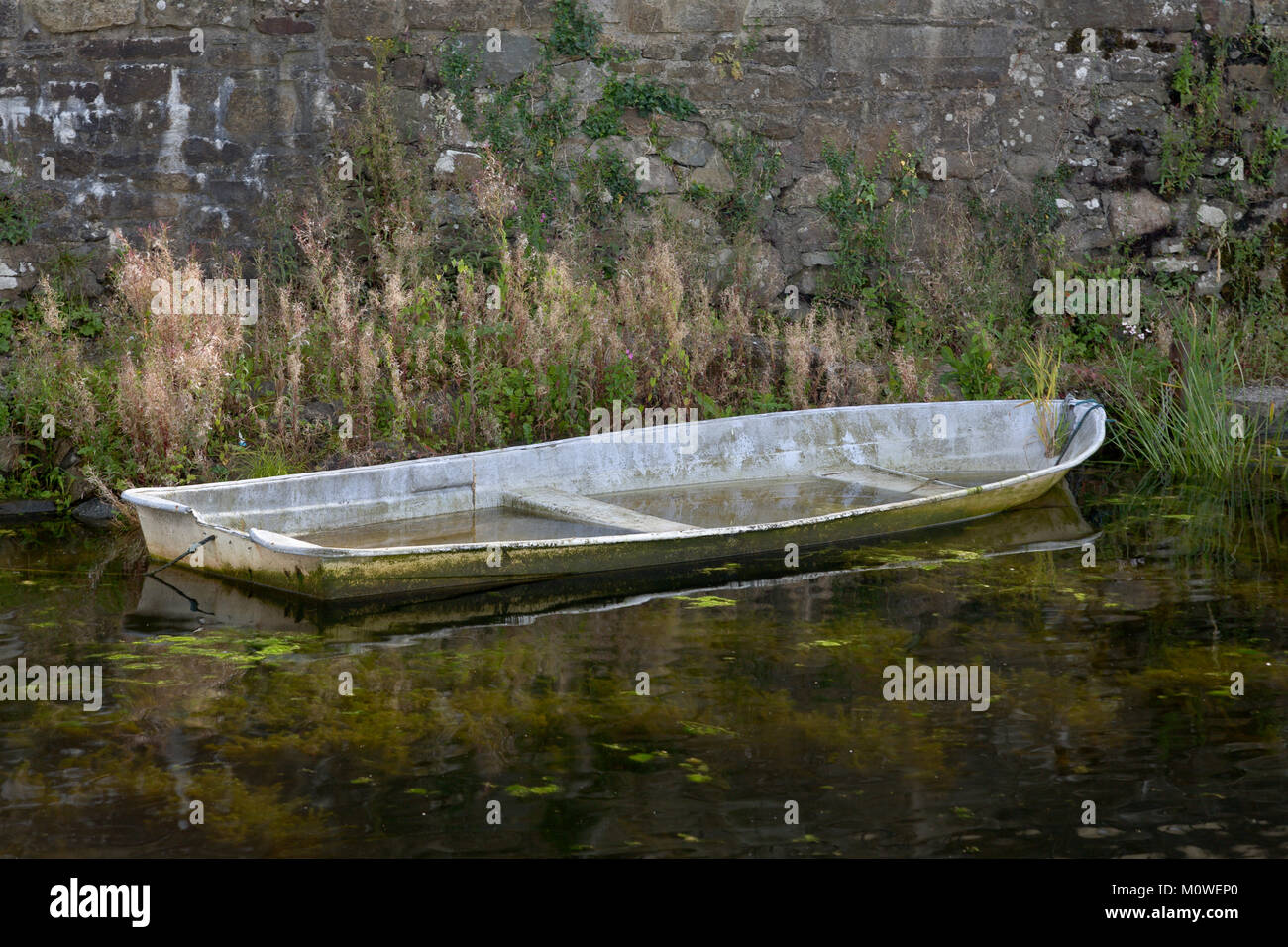 Broken rowing boat filled with water in a river at Killaloe, Ireland ...