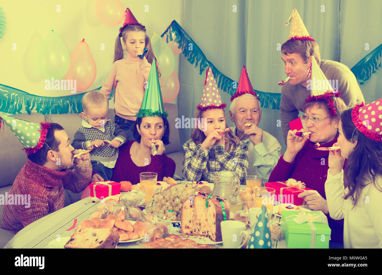 Smiling family behaving jokingly during children’s birthday party Stock ...