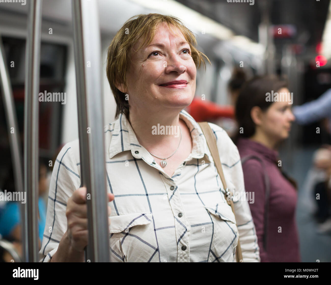 Smiling senior woman commuter taking journey in public train Stock ...