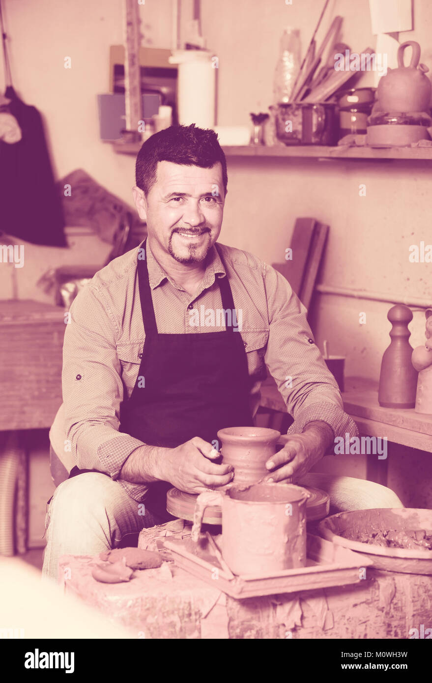 smiling russian artisan man creating ceramic piece on spinning pottery ...