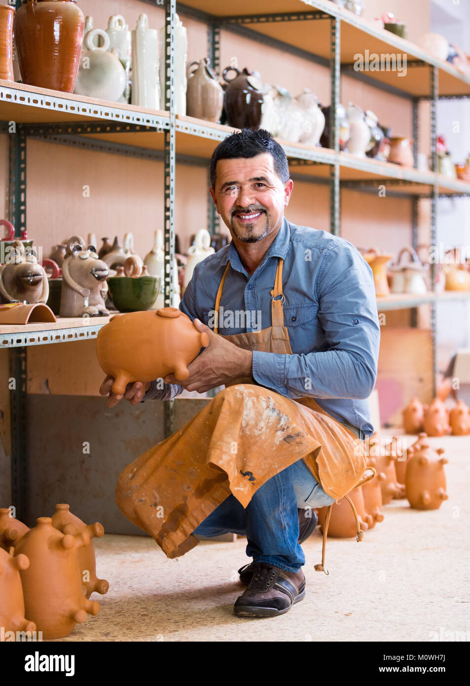 cheerful man potter holding ceramic vessels in atelier Stock Photo - Alamy