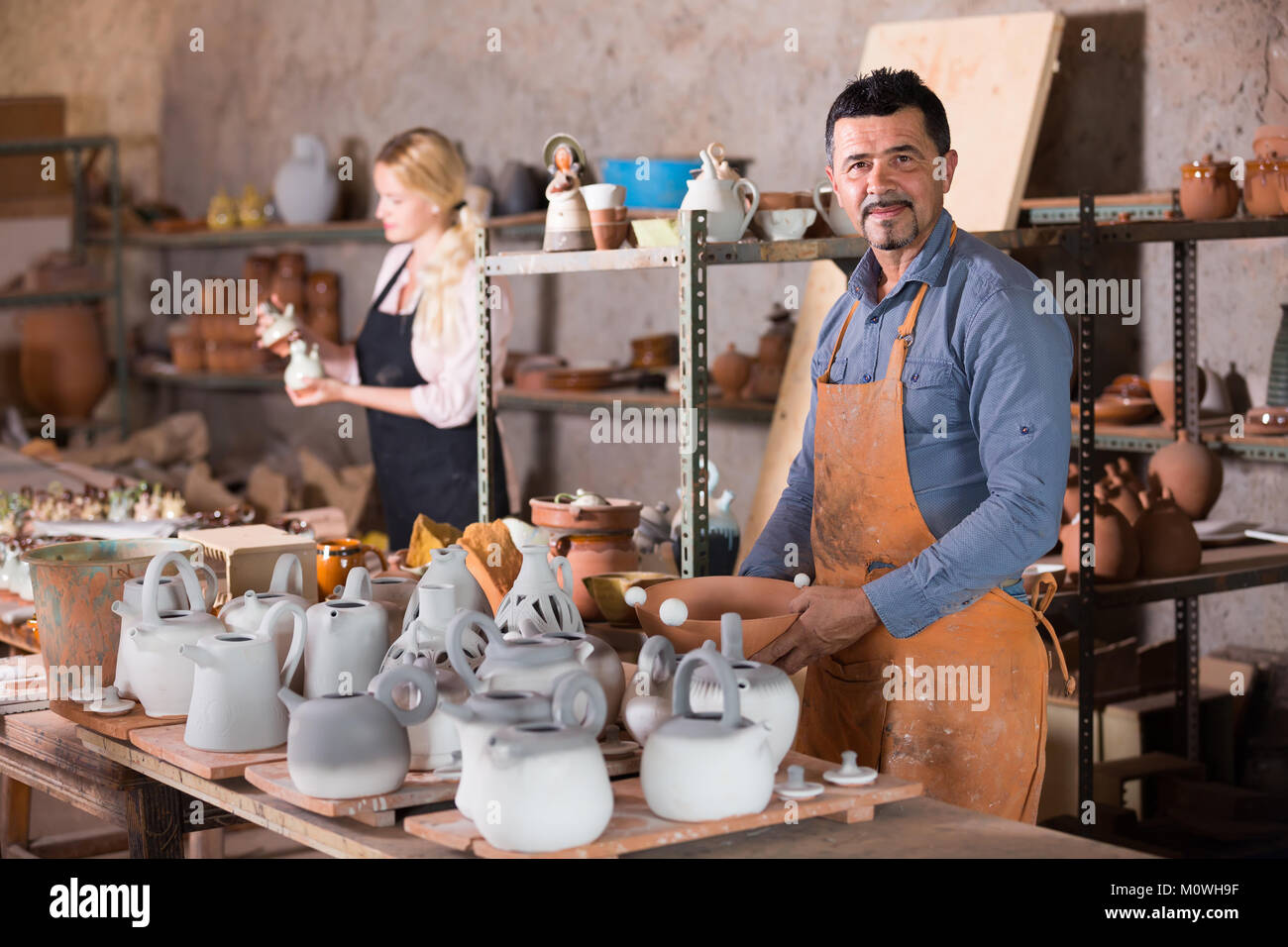 portrait of two joyful smiling potters working with ceramics and ...
